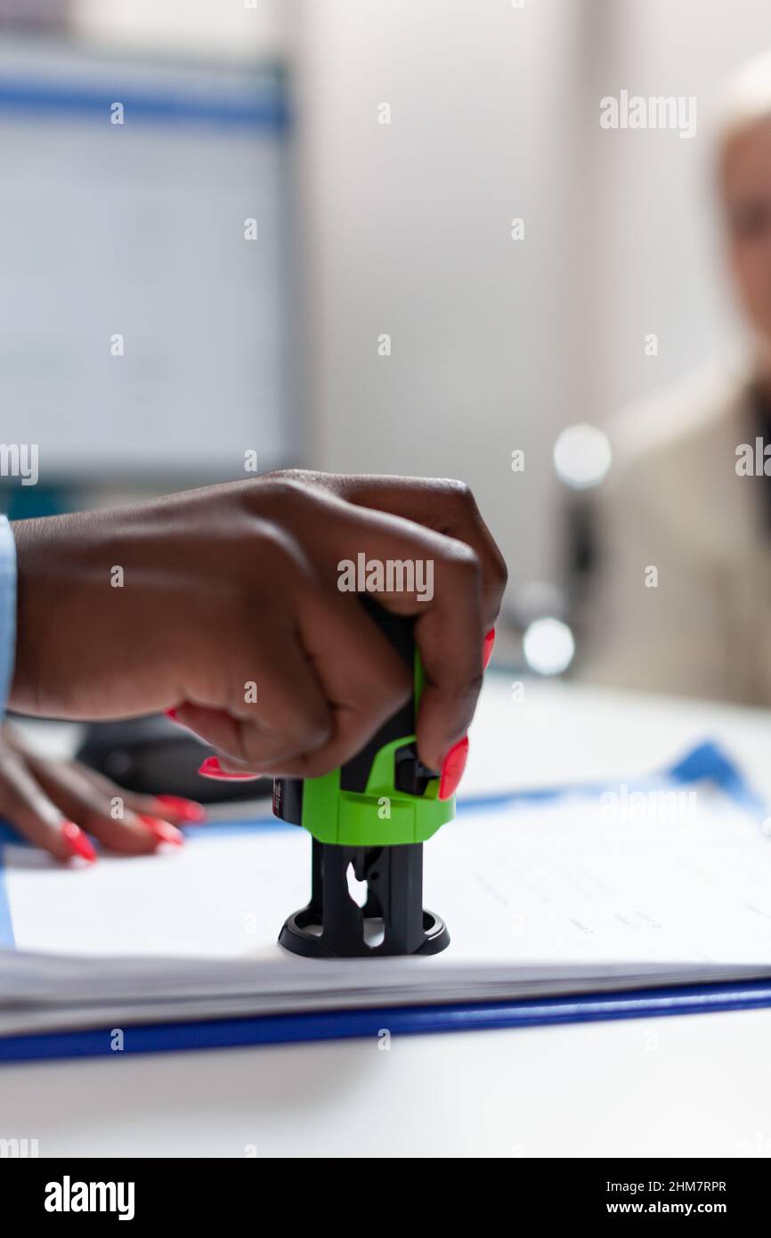 Closeup of african american therapist doctor hand stamping paper with ...