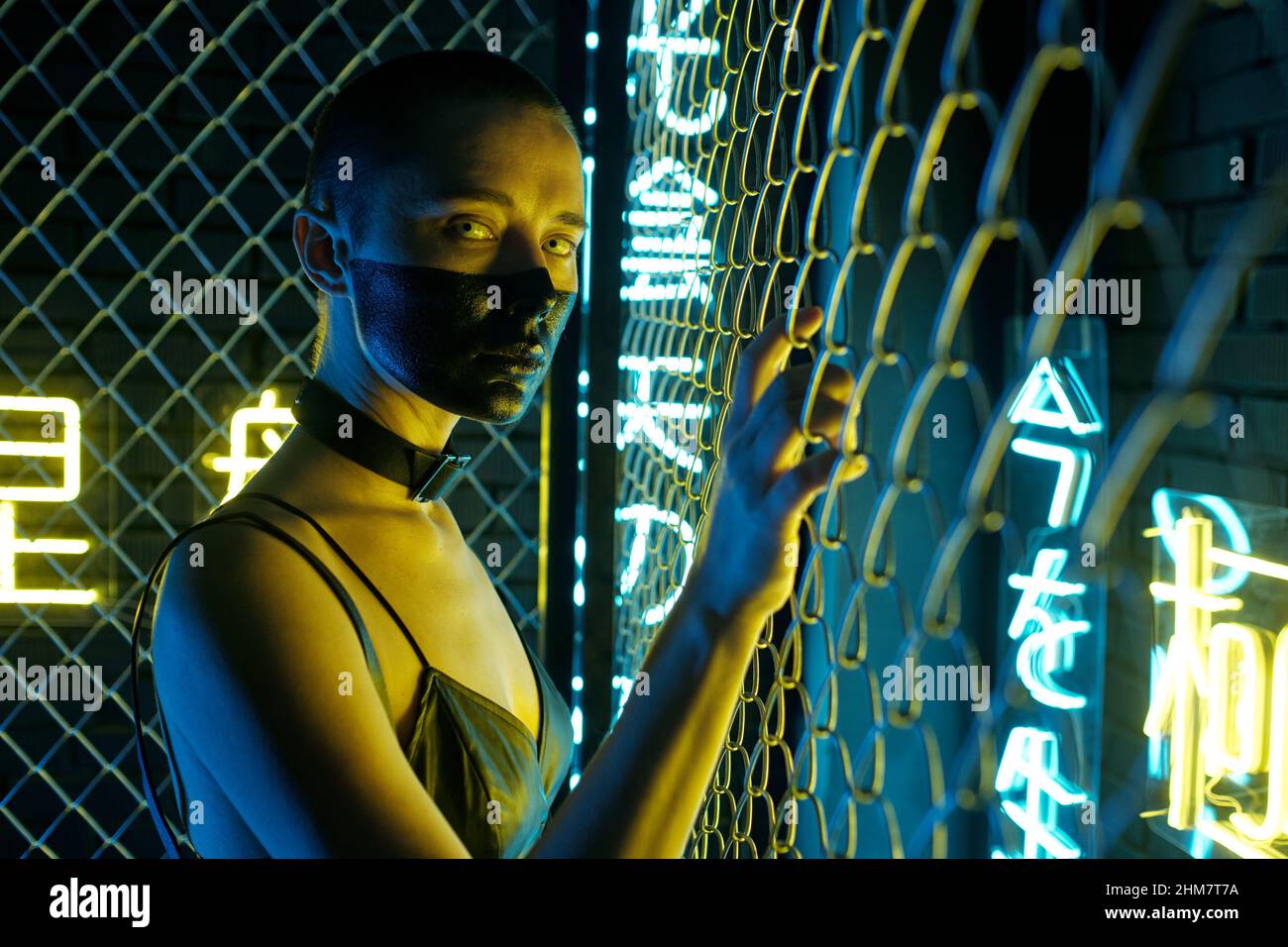Portrait of cyberpunk woman with black paint on her face standing near ...