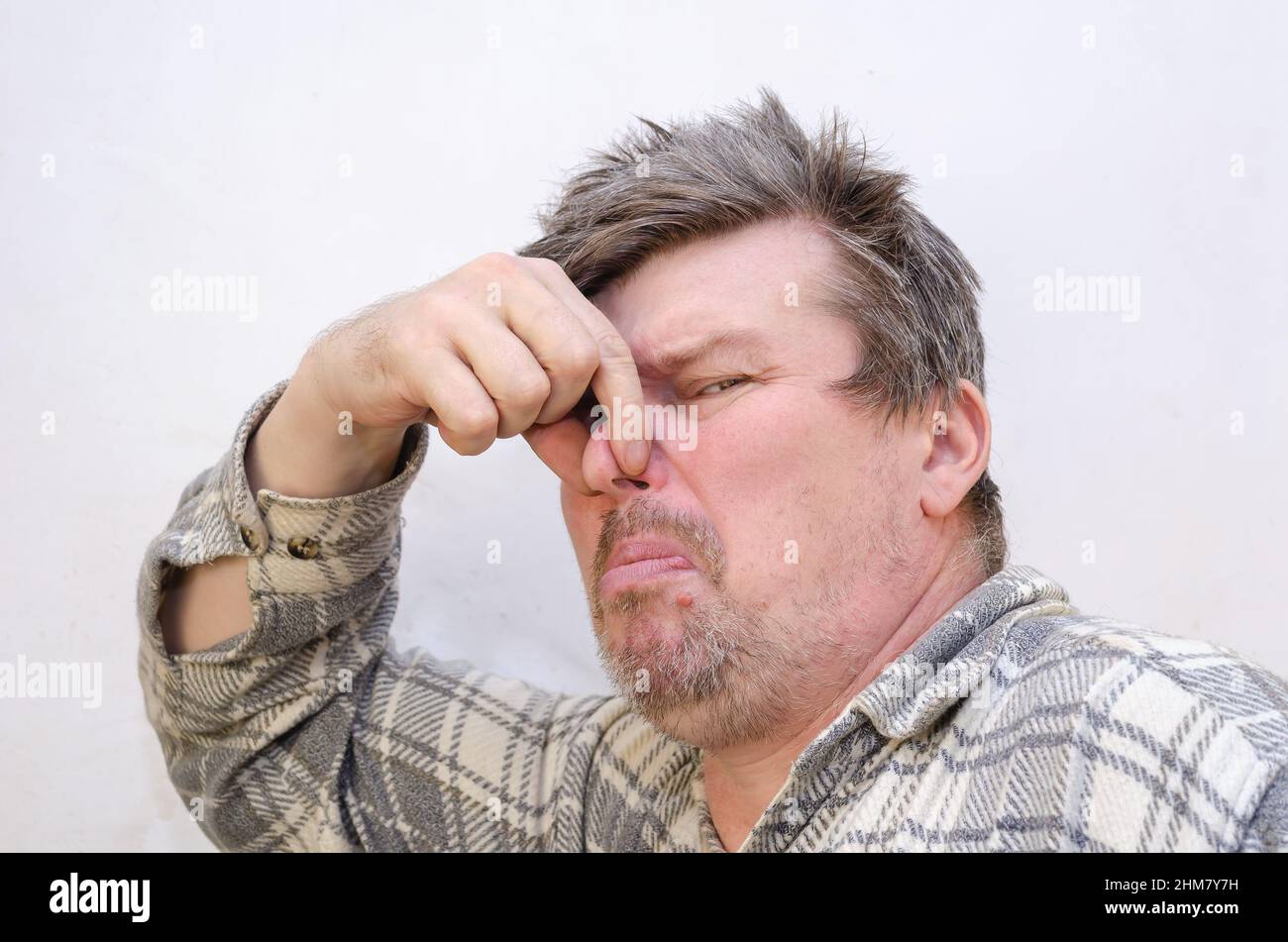 The man covers his nose with his fingers. An unpleasant smell. A male ...