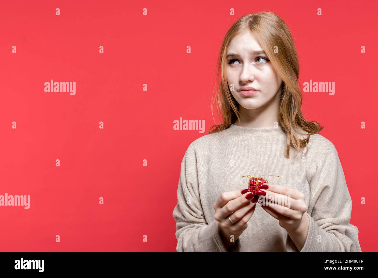 Girl frustrated holding a small gift box in her hands. Birthday ...