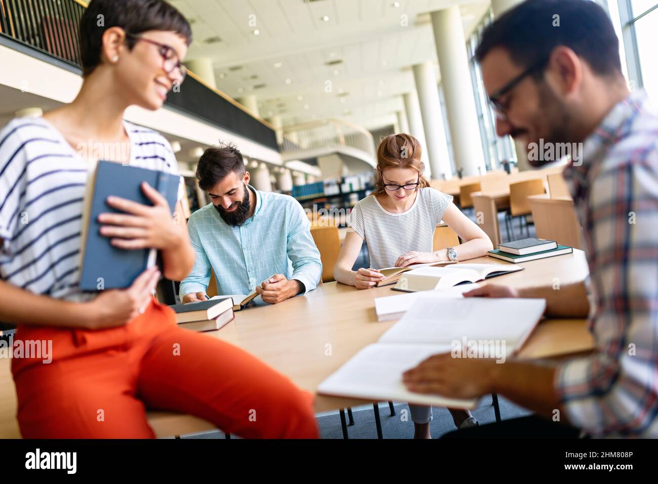 Happy group of students studying and working together in a college ...