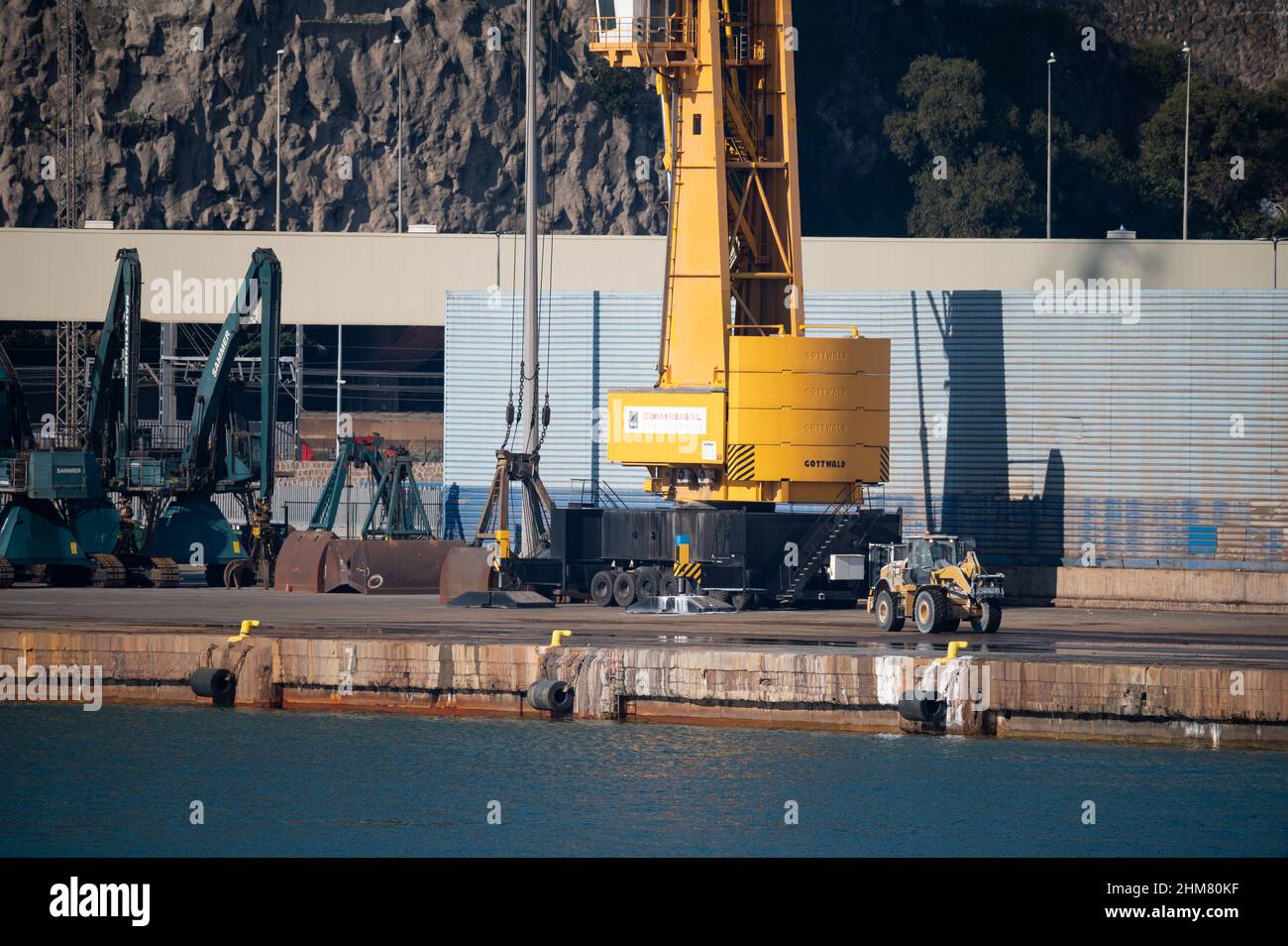 Industrial zone of the port, machinery, cranes, and tractor to carry ...