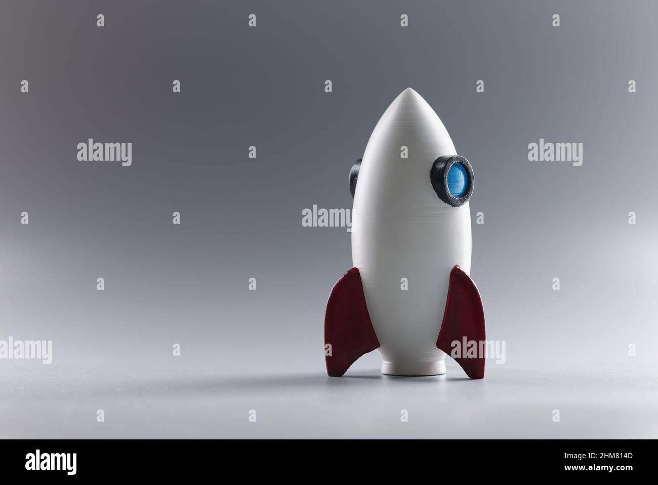Rocket toy model stand on grey surface, rocketship as symbol for ...