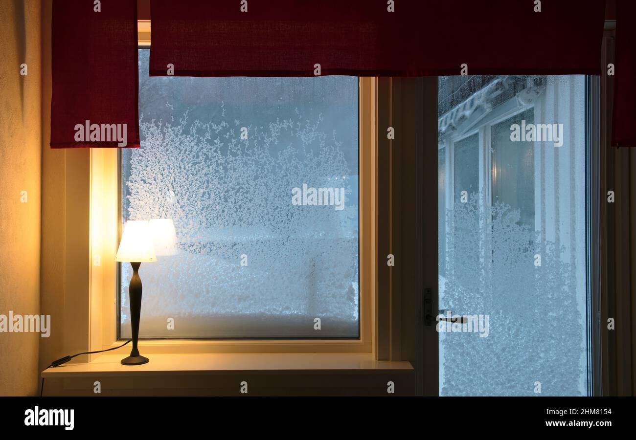 A snowy window, wet clusters during a blizzard. View from indoor ...