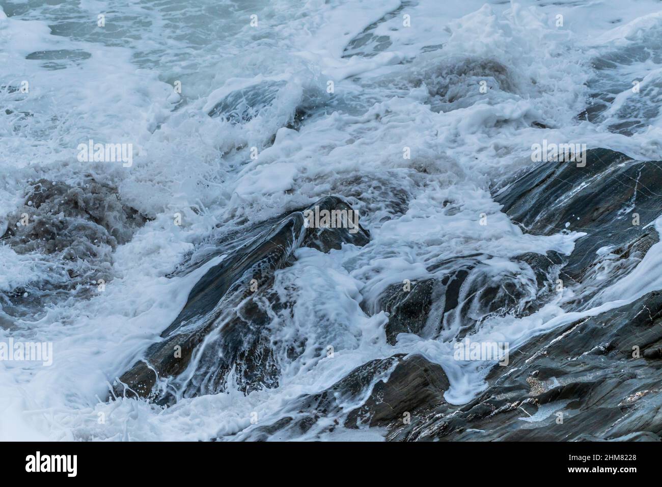 Incoming tide flowing over rocks Stock Photo - Alamy