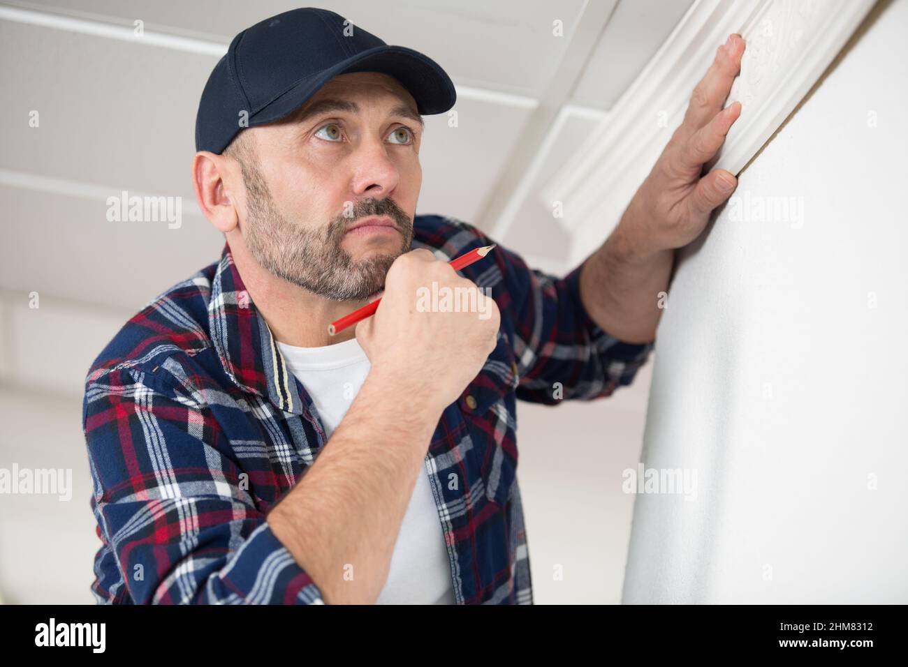 male decorator contemplating installation of a wall adornment Stock ...