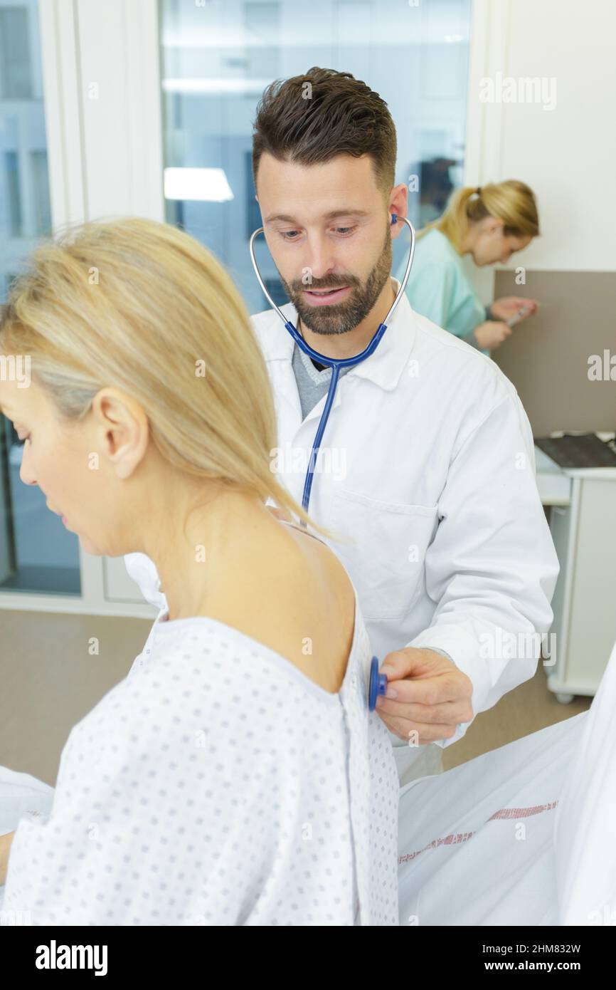 doctor holding stethoscope to patients back Stock Photo - Alamy