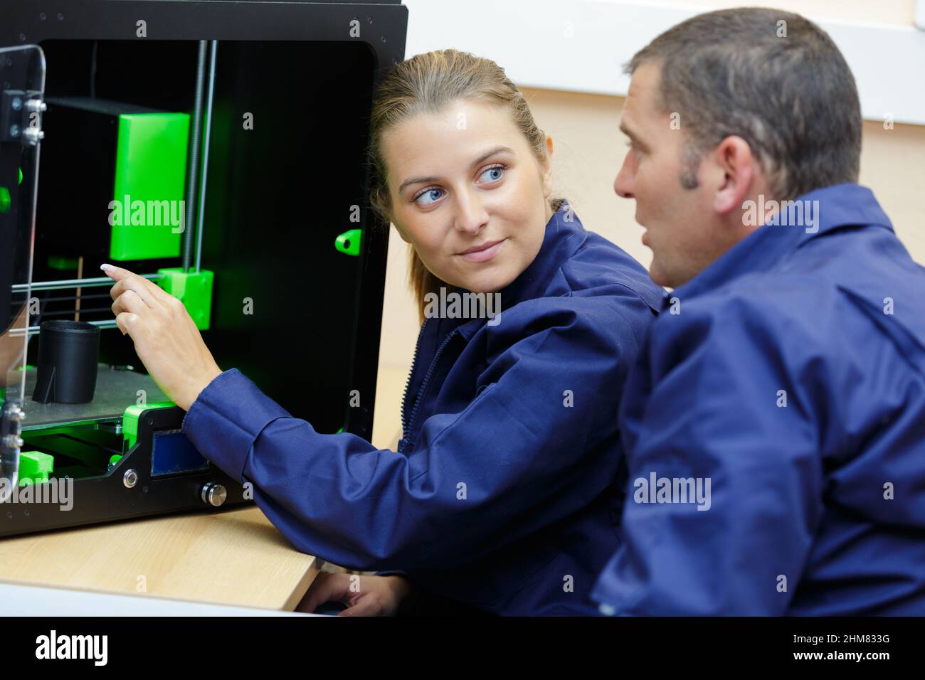mechanical engineer talking to female apprentice Stock Photo - Alamy