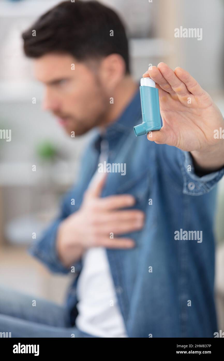young man using asthma inhaler at home Stock Photo - Alamy