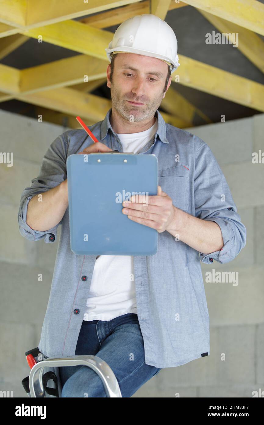 smart pensive builder with clipboard Stock Photo - Alamy