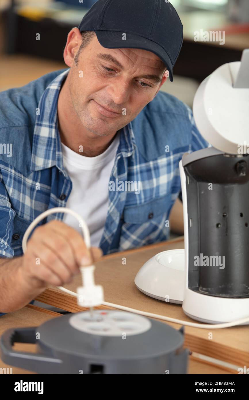 serious man repairing broken coffee machine Stock Photo - Alamy