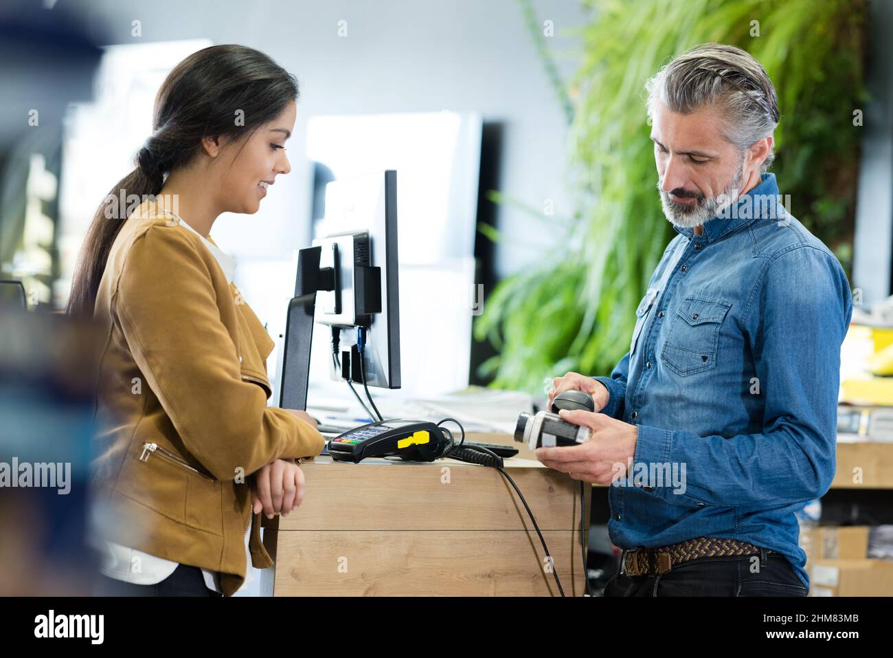 mature male sales assistant scanning product at counter Stock Photo - Alamy