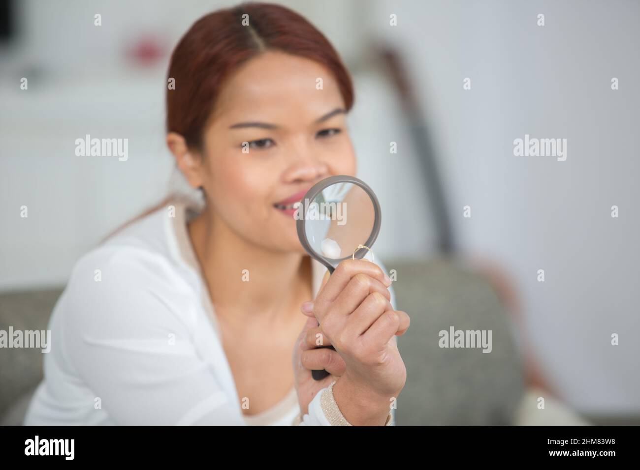 woman looking at the ring through magnifying glass Stock Photo - Alamy