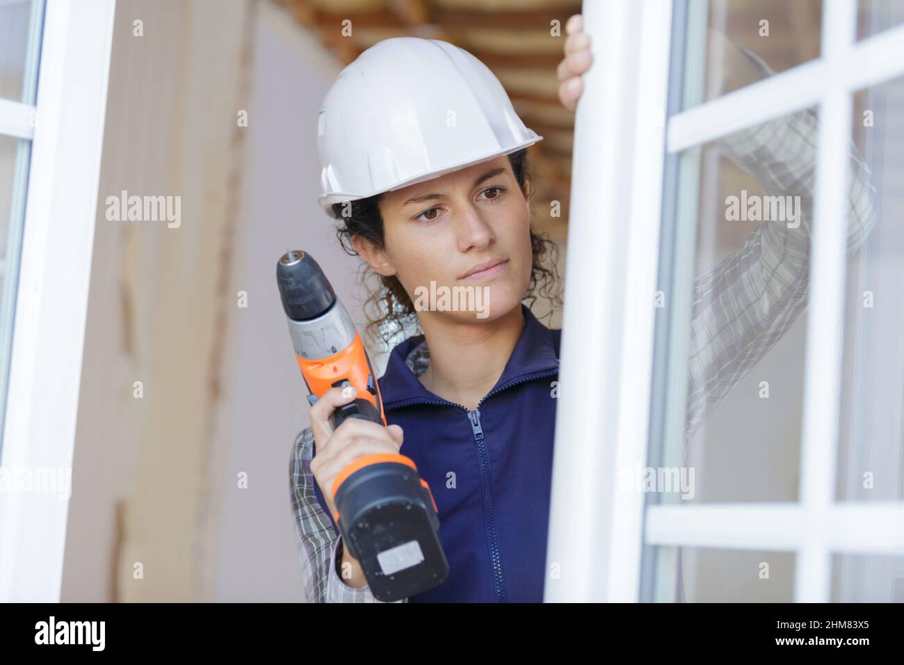 construction worker drilling a window Stock Photo - Alamy
