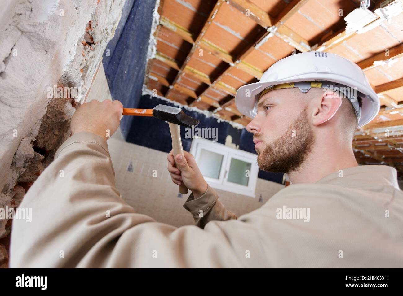low angle view of builder using hammer and chisel Stock Photo - Alamy