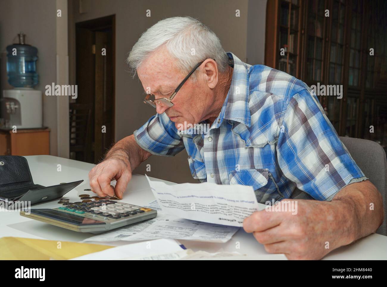 Senior man sitting at the table and calculating finances. Old man ...