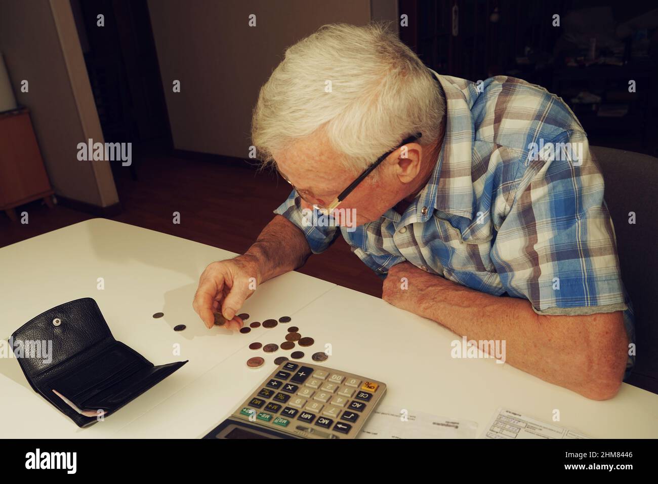 Upset Senior man sitting at the table and calculating finances. Old man ...