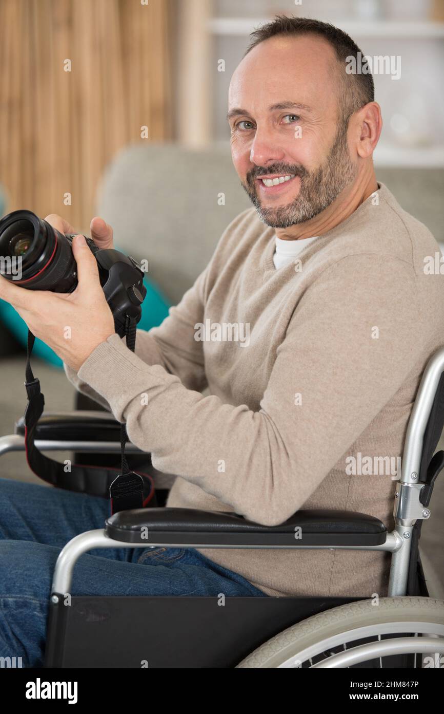 male photographer on wheelchair holding camera indoor Stock Photo - Alamy