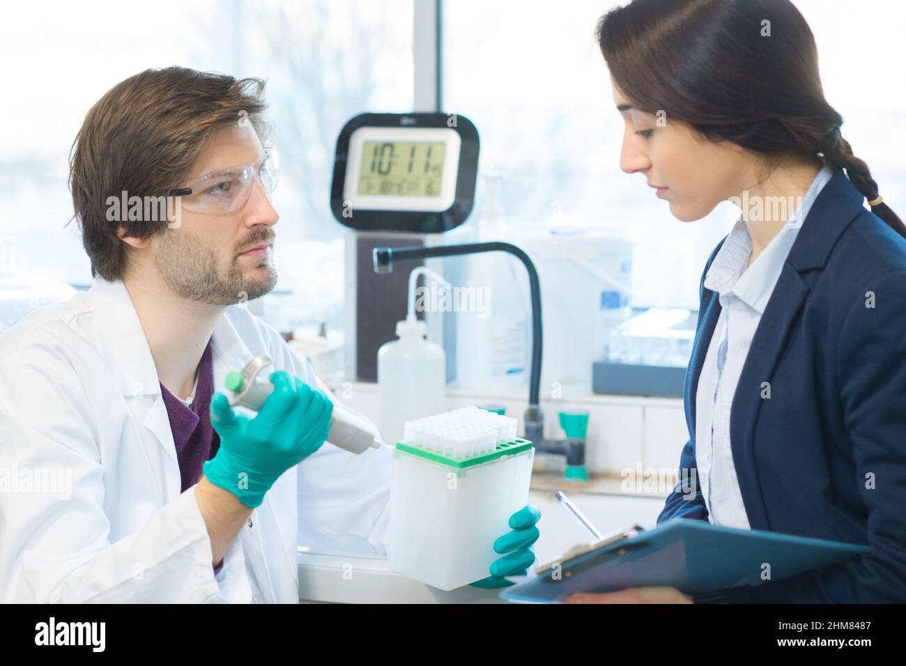 laboratory technician holding plastic container and pipette Stock Photo ...