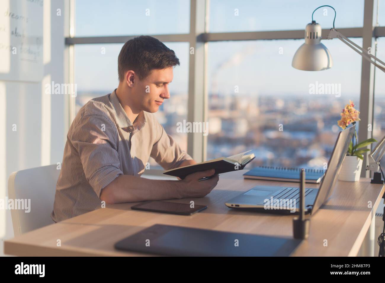 Female writer working in light modern office, writing down new ideas in ...