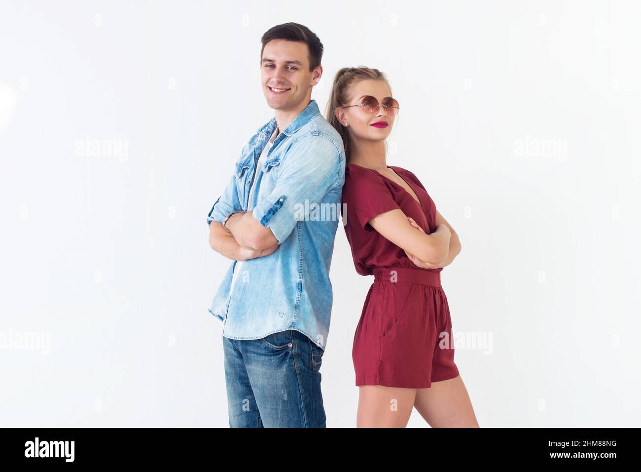 Smiling young couple standing together on white background Stock Photo ...