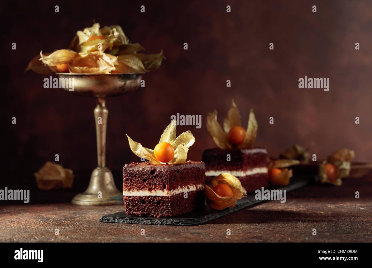Chocolate cake with physalis on a brown background. Copy space Stock ...