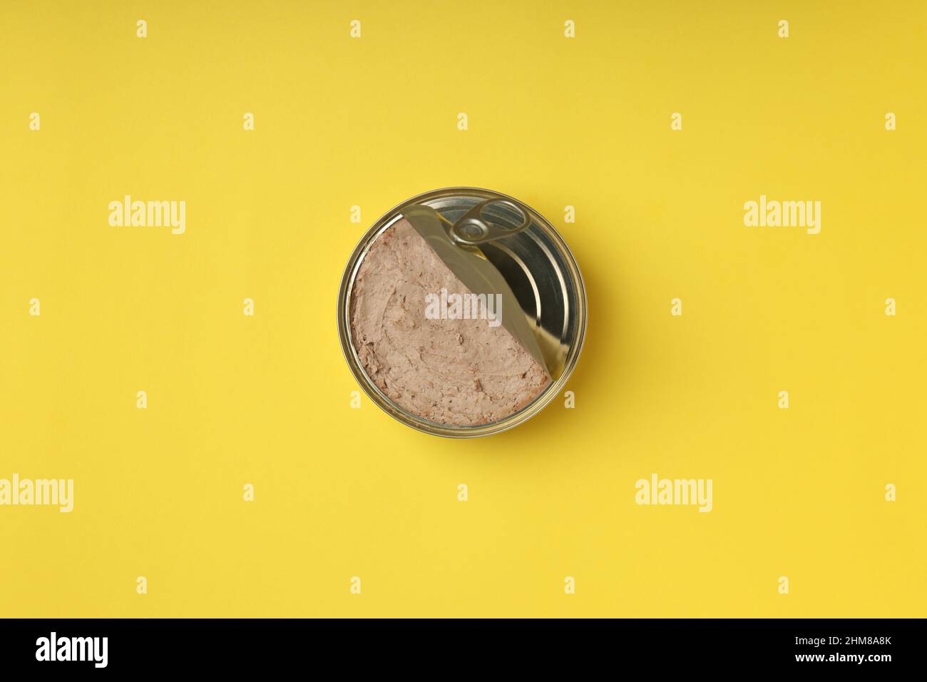 Tin can of pate on yellow background Stock Photo - Alamy