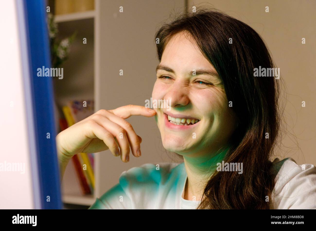 The woman looks at the computer screen and smiles Stock Photo - Alamy