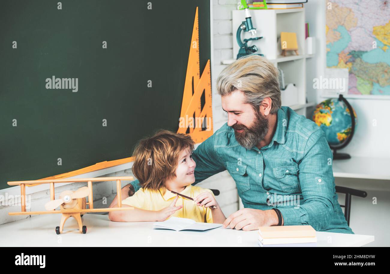 Kid and teacher is learning in class on background of blackboard ...