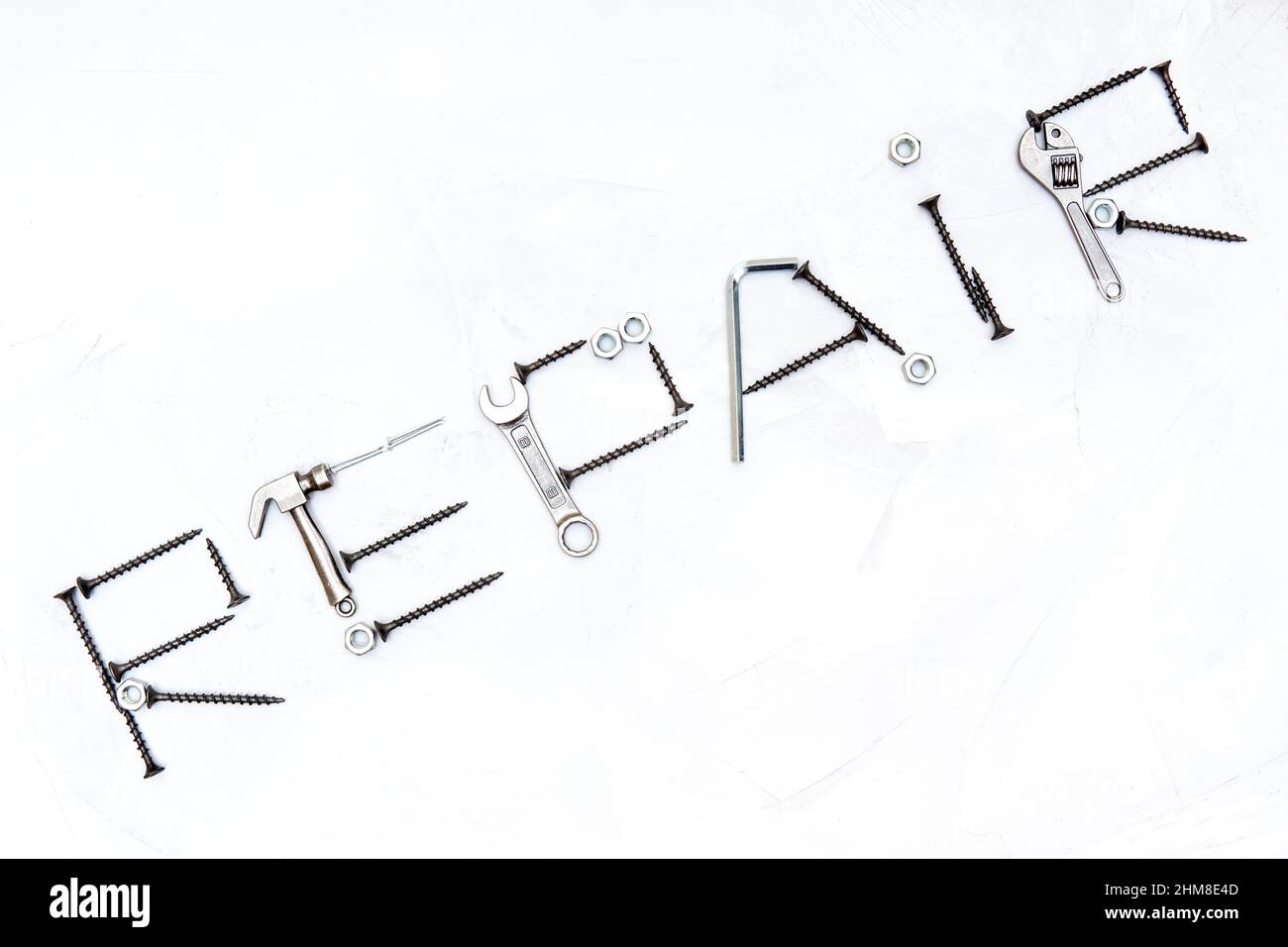 Word REPAIR made from miniature steel copies of hand tools, screws and ...