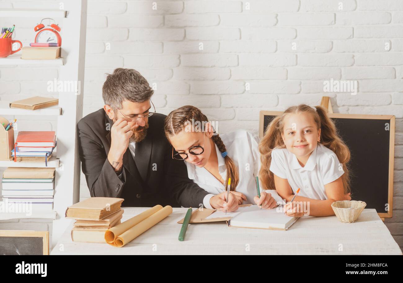 Dad teaching schoolchild girls. Father and school kids daughters at ...