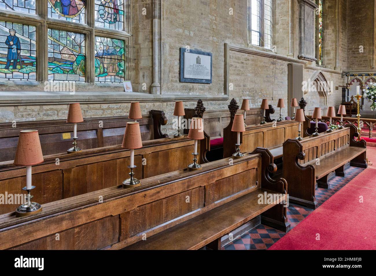 Stained glass and pews, interior of the church of St Peter and St Paul ...