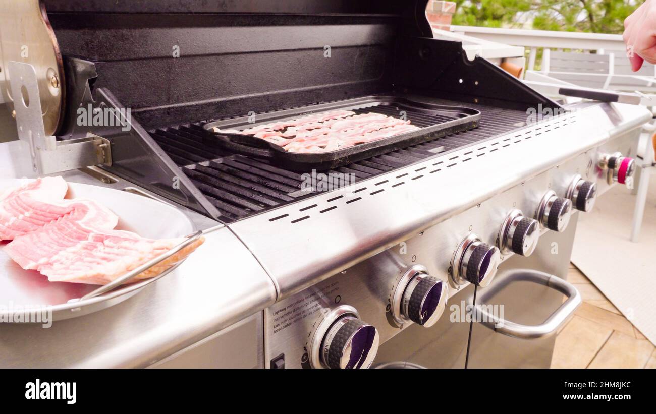Cooking bacon stips on an outdoor gas grill Stock Photo - Alamy