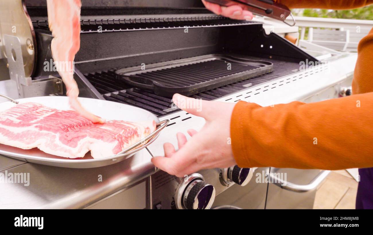 Cooking bacon stips on an outdoor gas grill Stock Photo - Alamy