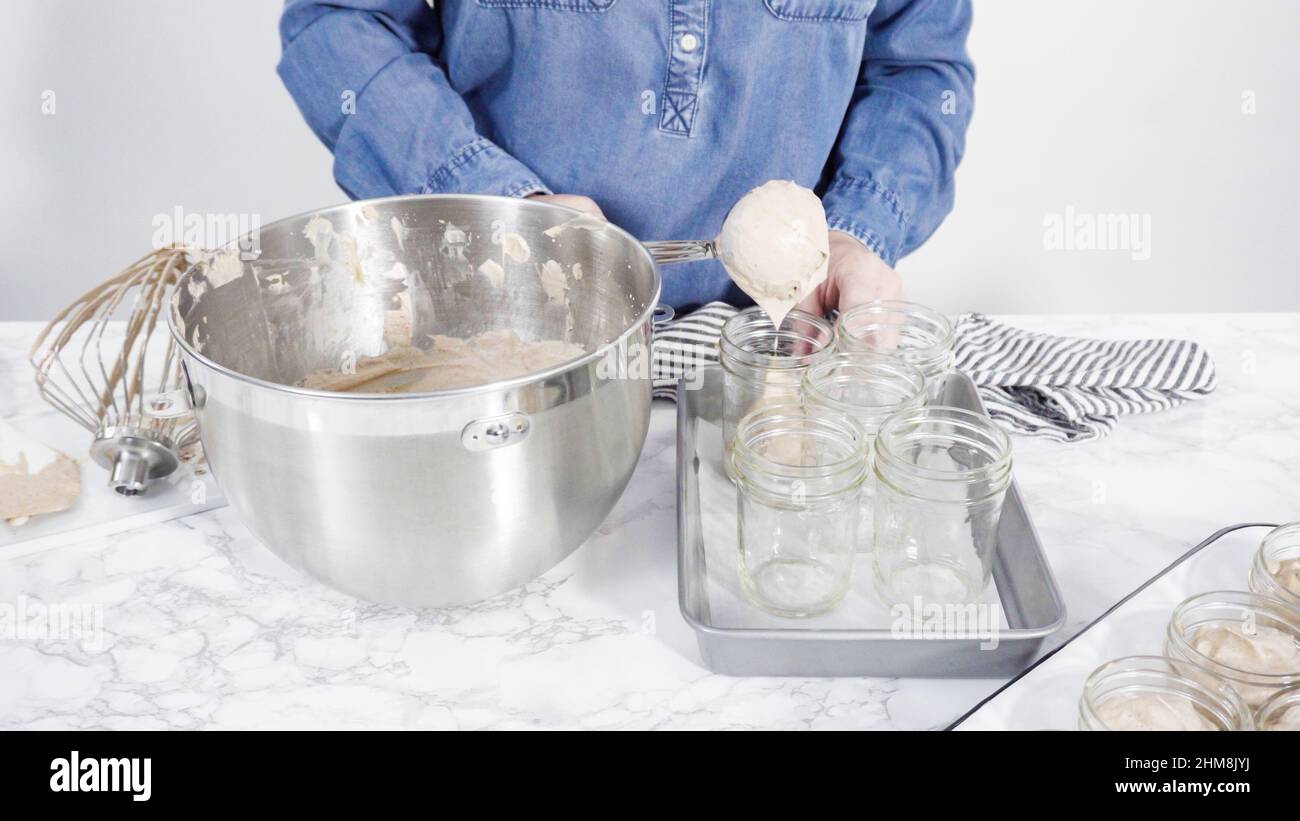 Step by step. Scooping homemade chocolate ice cream into glass jars ...