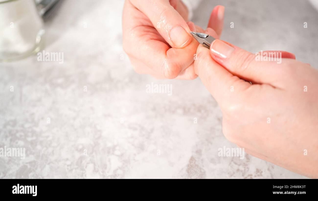 Woman finishing her manicure at home with simple manicure tools ...