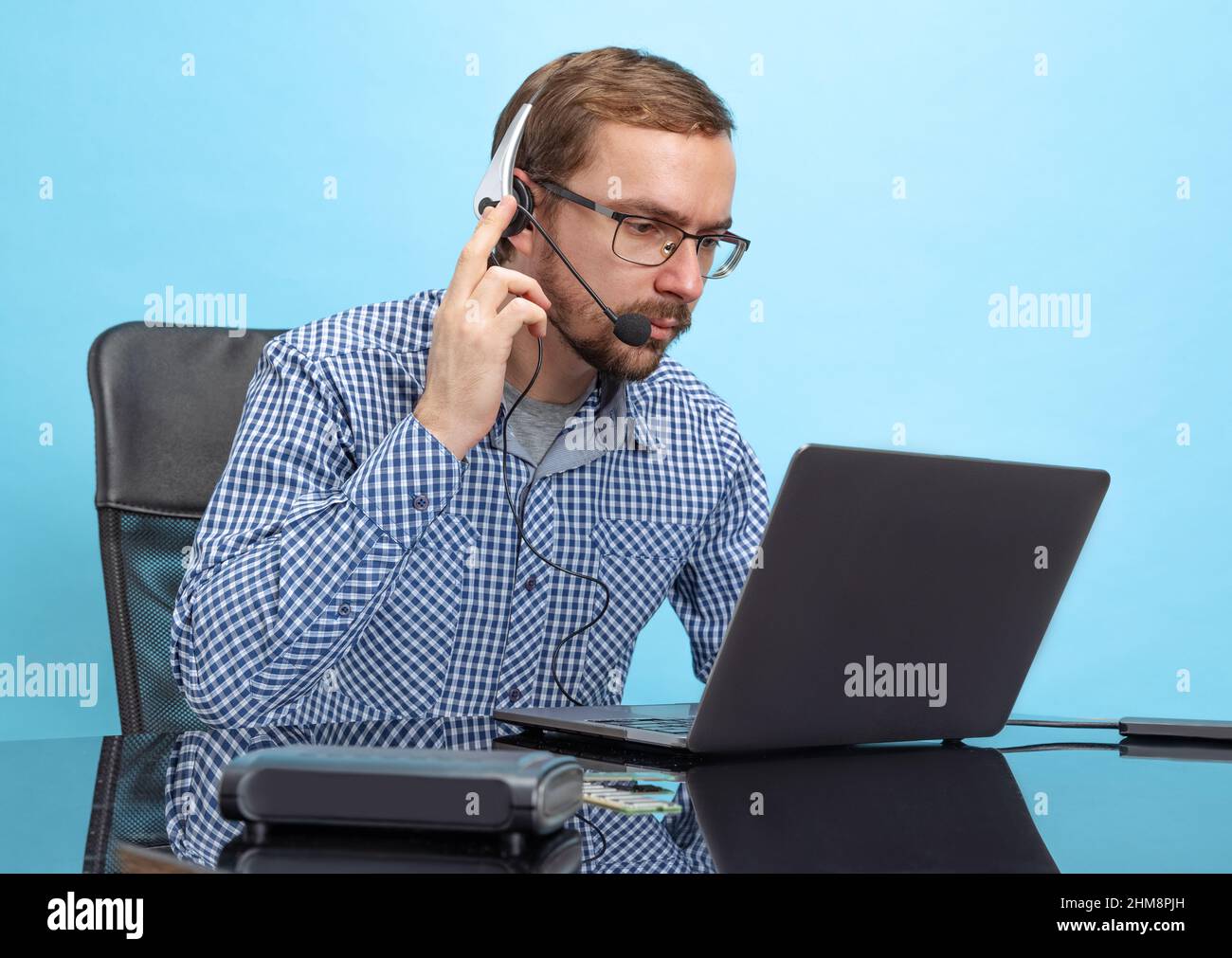 Portrait of concentrated man, call center operator working with laptop ...