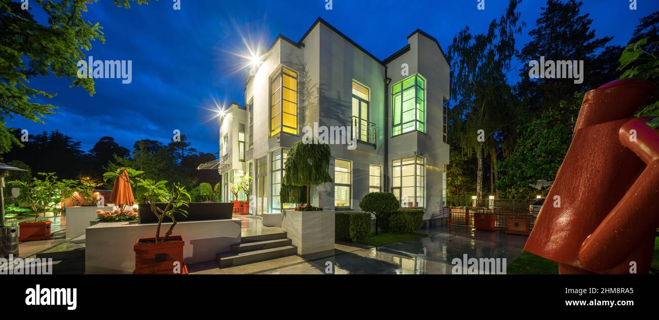 Modern exterior of luxury private house. Illuminated cottage at summer ...