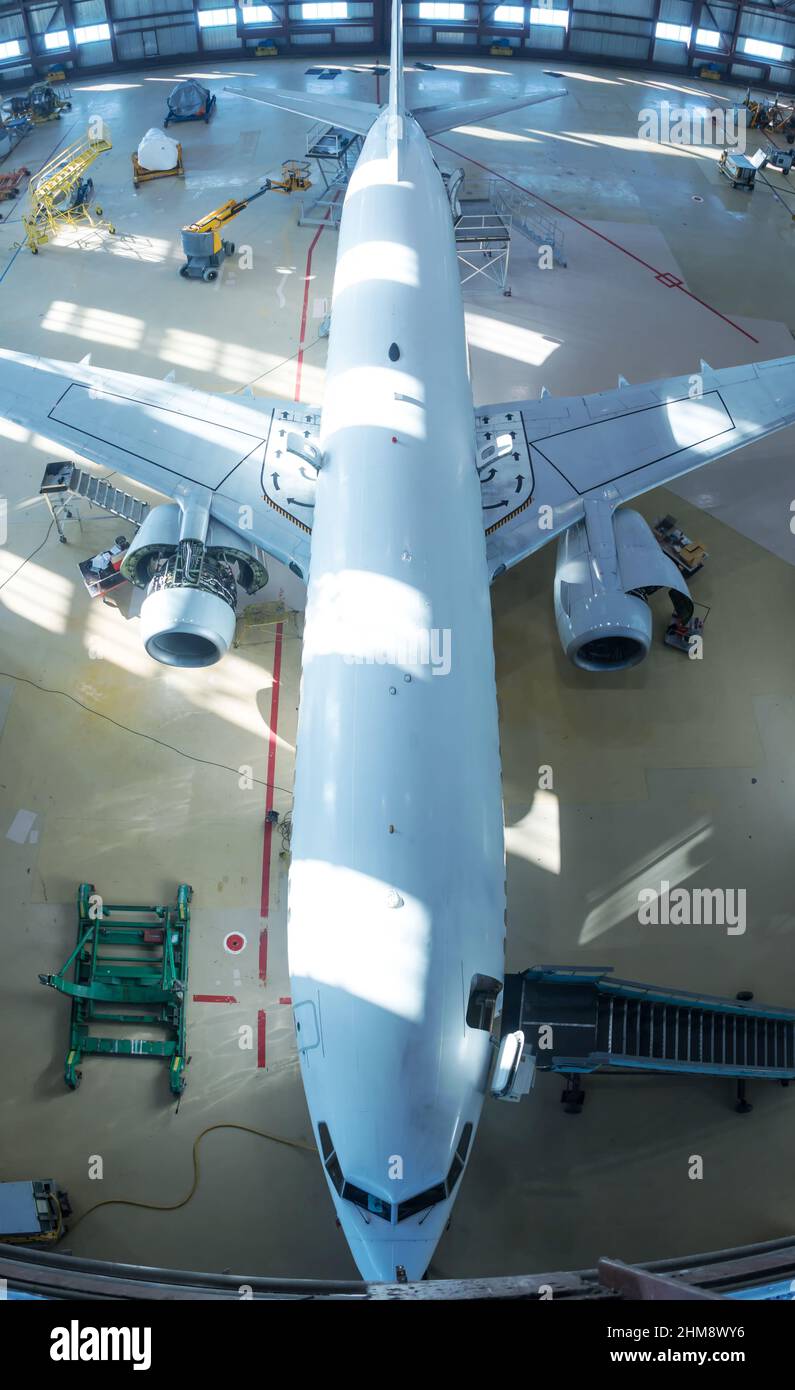 Top view of a white passenger jet plane in the hangar. Airplane under ...