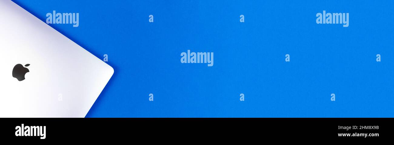 Apple Macbook on bright blue table background, banner with space for ...