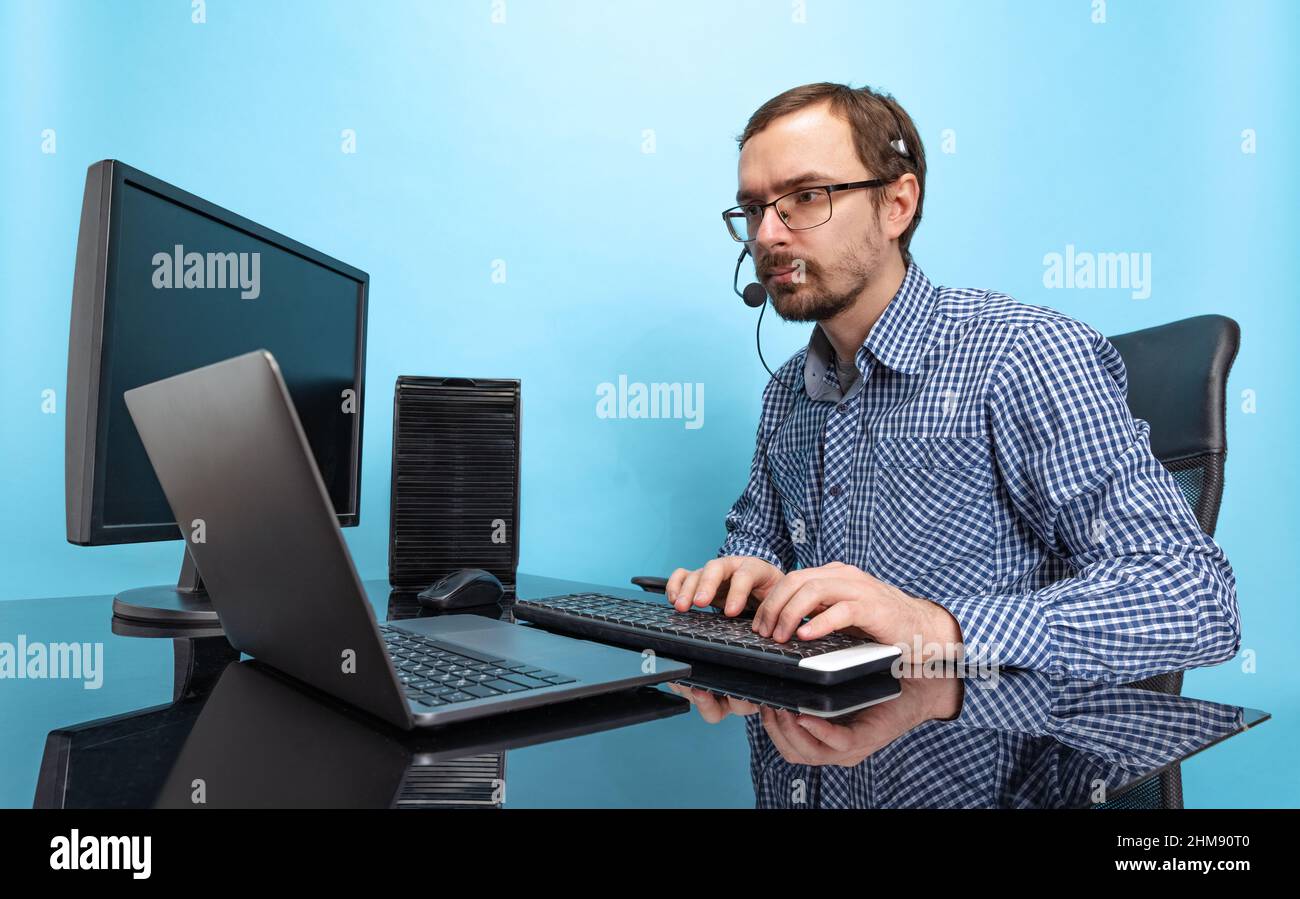 Portrait of concentrated man, call center operator working with laptop ...