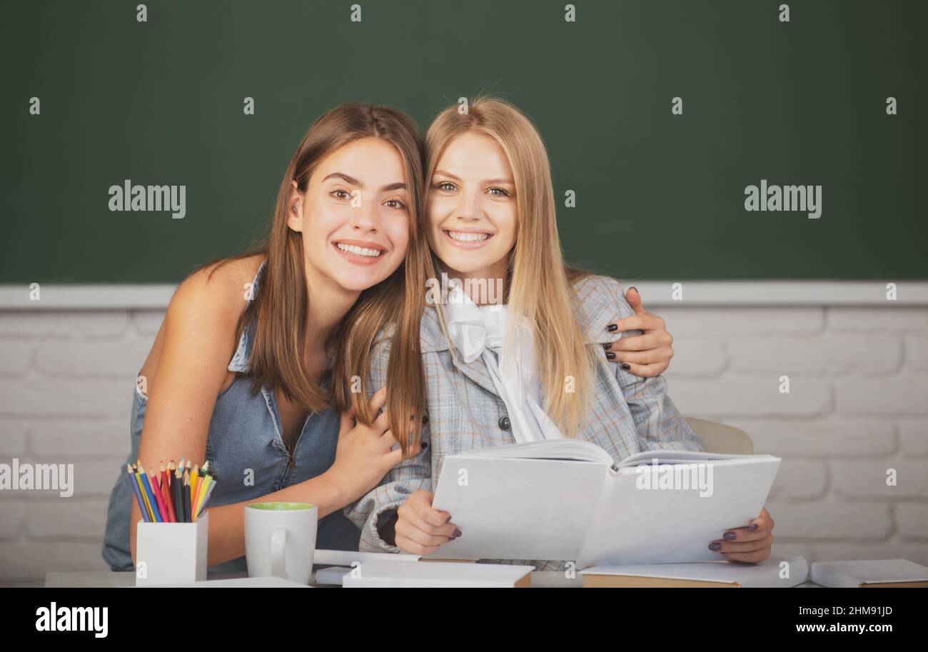 Happy smiling students girls hugging and embrace in classroom at ...
