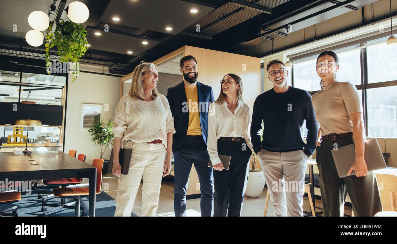 Successful business professionals standing together in an office. Team ... Successful business professionals standing together in an office. Team ...