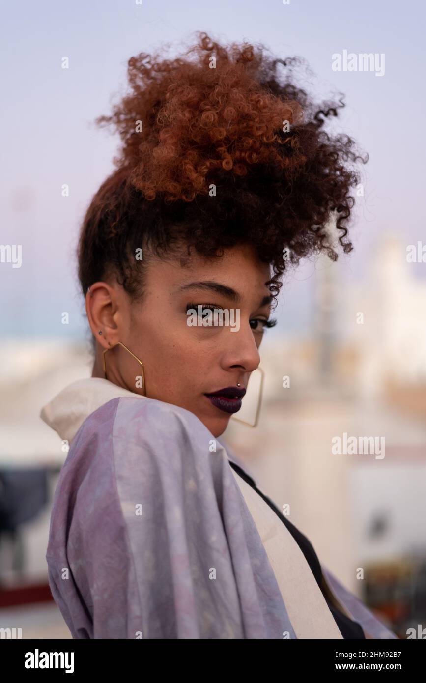 Stylish black female with curly hair and black lips wearing a kimono on ...