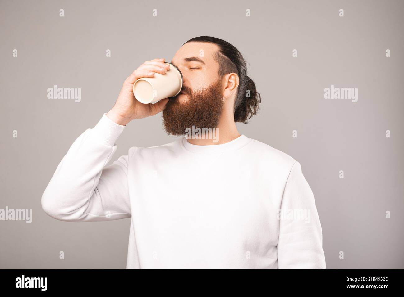 Phot of tired office worker man drinking cup of coffee for more cafeine ...