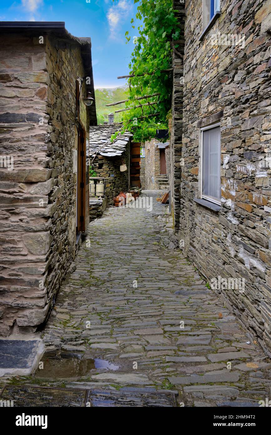 Narrow cobbled street and schist houses in the medieval mountain ...