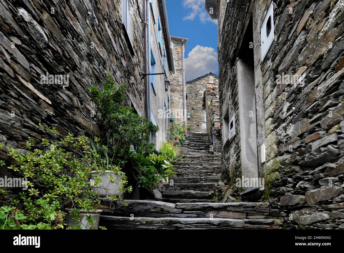 Narrow cobbled street and schist houses in the medieval mountain ...
