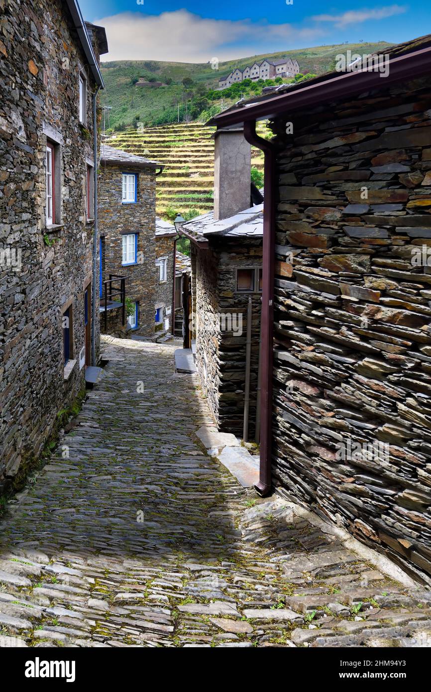 Narrow cobbled street and schist houses in the medieval mountain ...