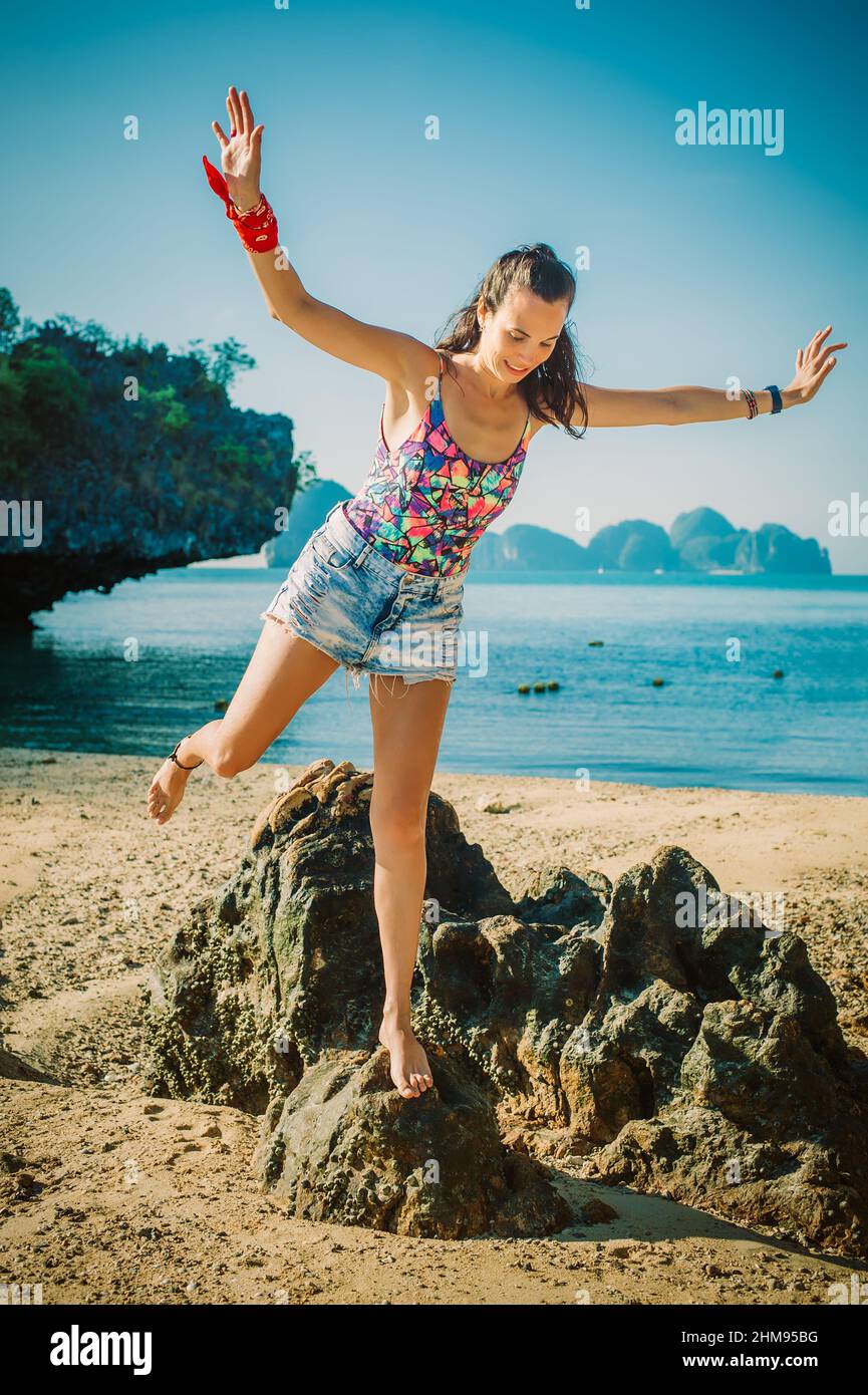 Portraits of happy young woman jumping on the beach Stock Photo - Alamy