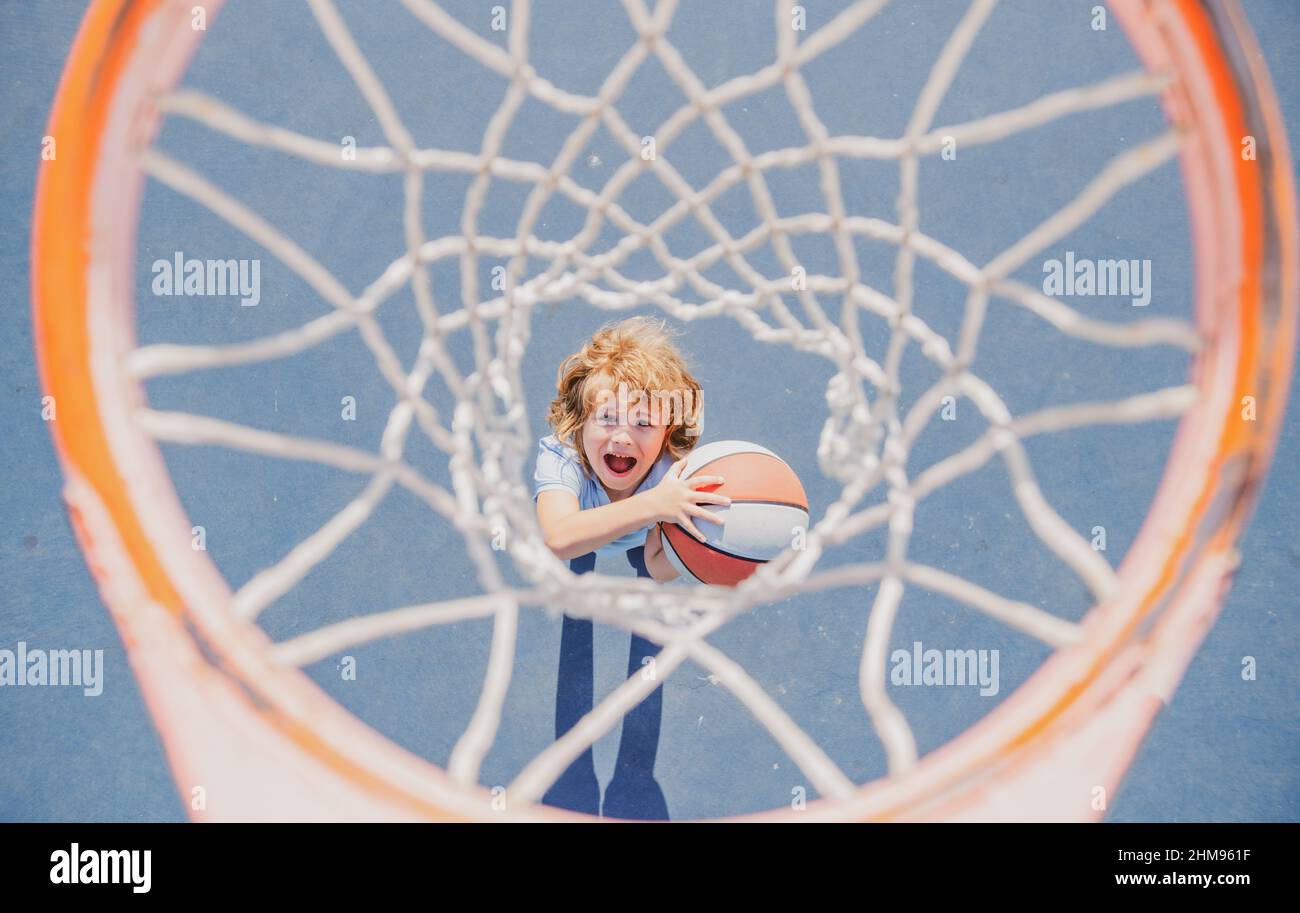 Top view of excited child playing basketball holding ball with happy ...